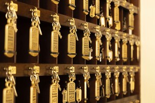 Uma parede com chaves de quarto, identificadas com números e nomes dos quartos.