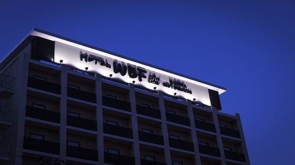 Um edifício de hotel com vários andares e uma placa grande no telhado.