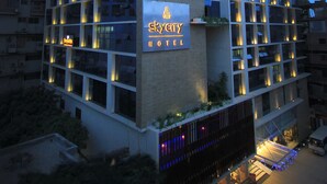 Um hotel com vários andares, janelas amplas e uma placa com a inscrição 'Skycity Hotel'.