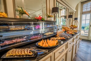 Buffet com diversos alimentos e um vaso decorativo.