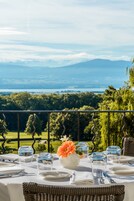 Mesa de jantar montada ao ar livre, com vista para uma paisagem montanhosa.