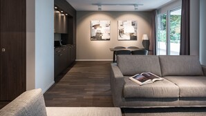 Uma sala de estar moderna com um sofá, uma mesa de centro e um espaço de jantar com cadeiras e uma mesa.
