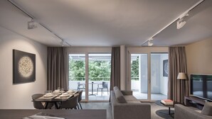 Uma sala de estar moderna com um sofá, uma mesa de jantar e uma televisão.