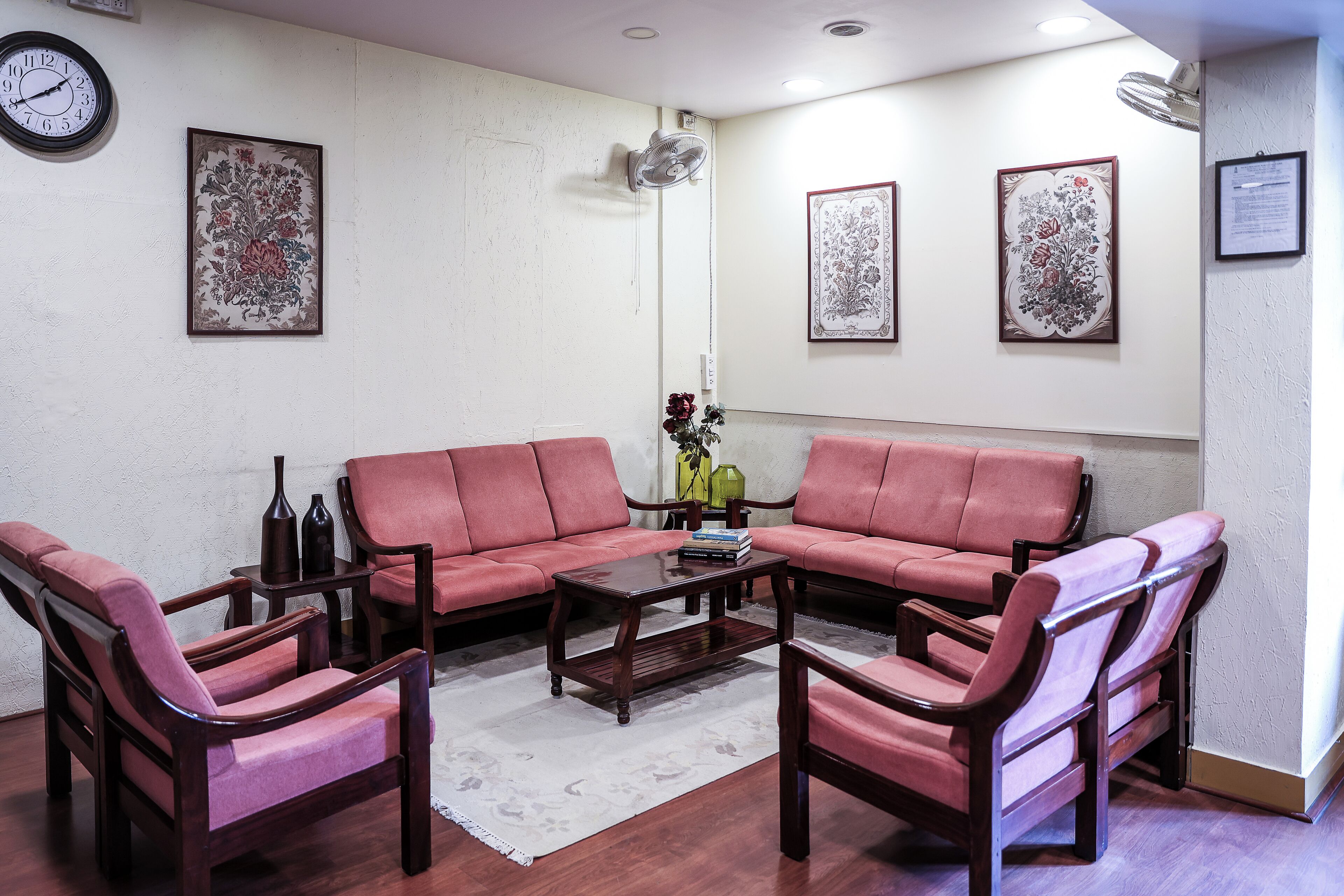 Uma sala de estar com um sofá, uma mesa de centro e um relógio na parede.