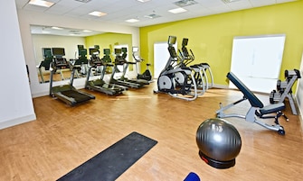 Academia com esteiras, elípticos e equipamentos de musculação.