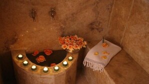Uma banheira de pedra com velas e flores.