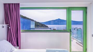Quarto com vista para uma varanda, uma cama e uma janela com cortinas.