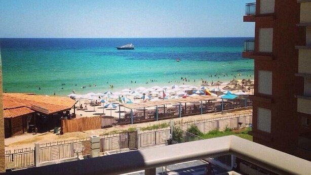 Uma área de piscina com vista para uma praia e o oceano.