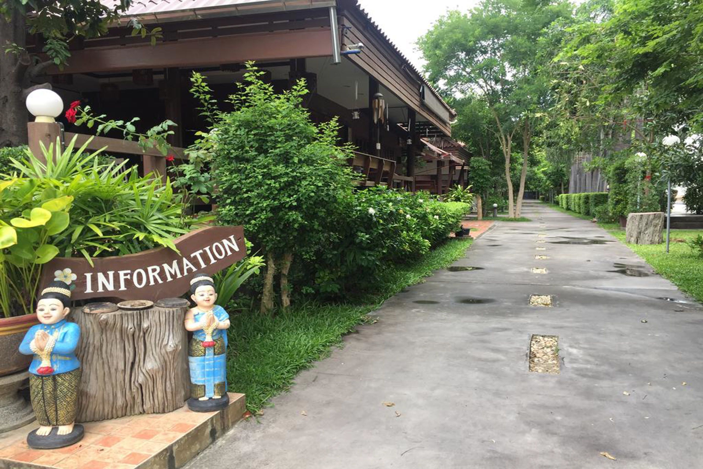 Uma passagem leva a um edifício com uma placa que diz 'INFORMATION'.