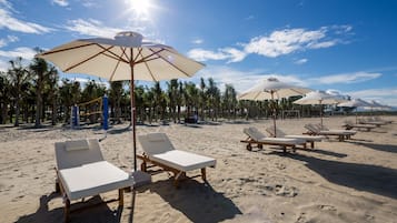 Uma praia privada, espreguiçadeiras, guarda-sóis de praia