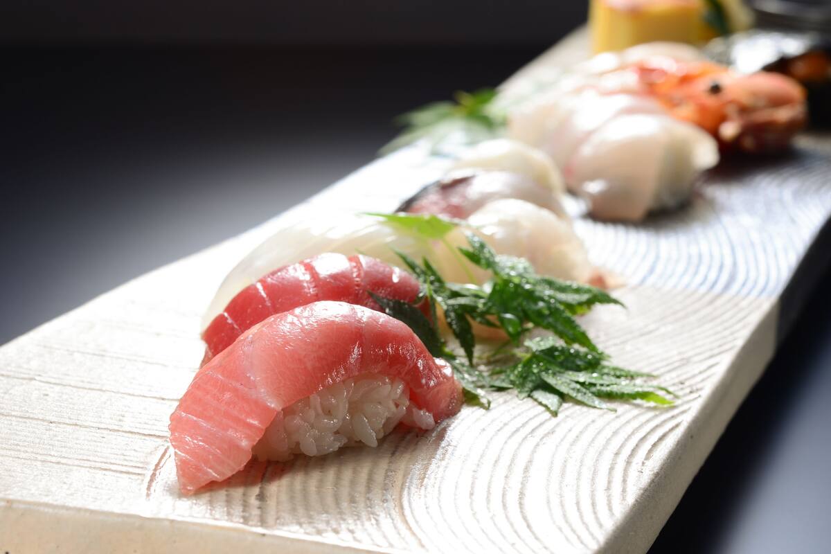 Uma bandeja de madeira com diversos tipos de sushi.