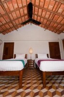 Quarto com duas camas, um ventilador de teto e piso estampado.