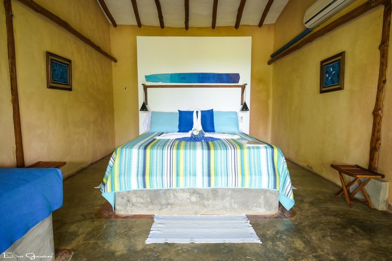 Um quarto com uma cama, uma mesinha e uma cadeira.