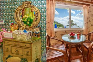Quarto com cômoda antiga, espelho e área de jantar com vista para o exterior.