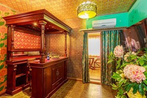 Um quarto com um armário de madeira, parede estampada e porta verde.