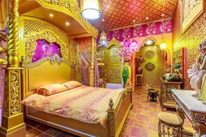 Um quarto ricamente decorado com uma cama grande, móveis ornamentados e uma estátua.