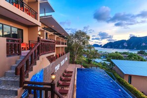 Um hotel com piscina, área de estar ao ar livre e vista para a água.