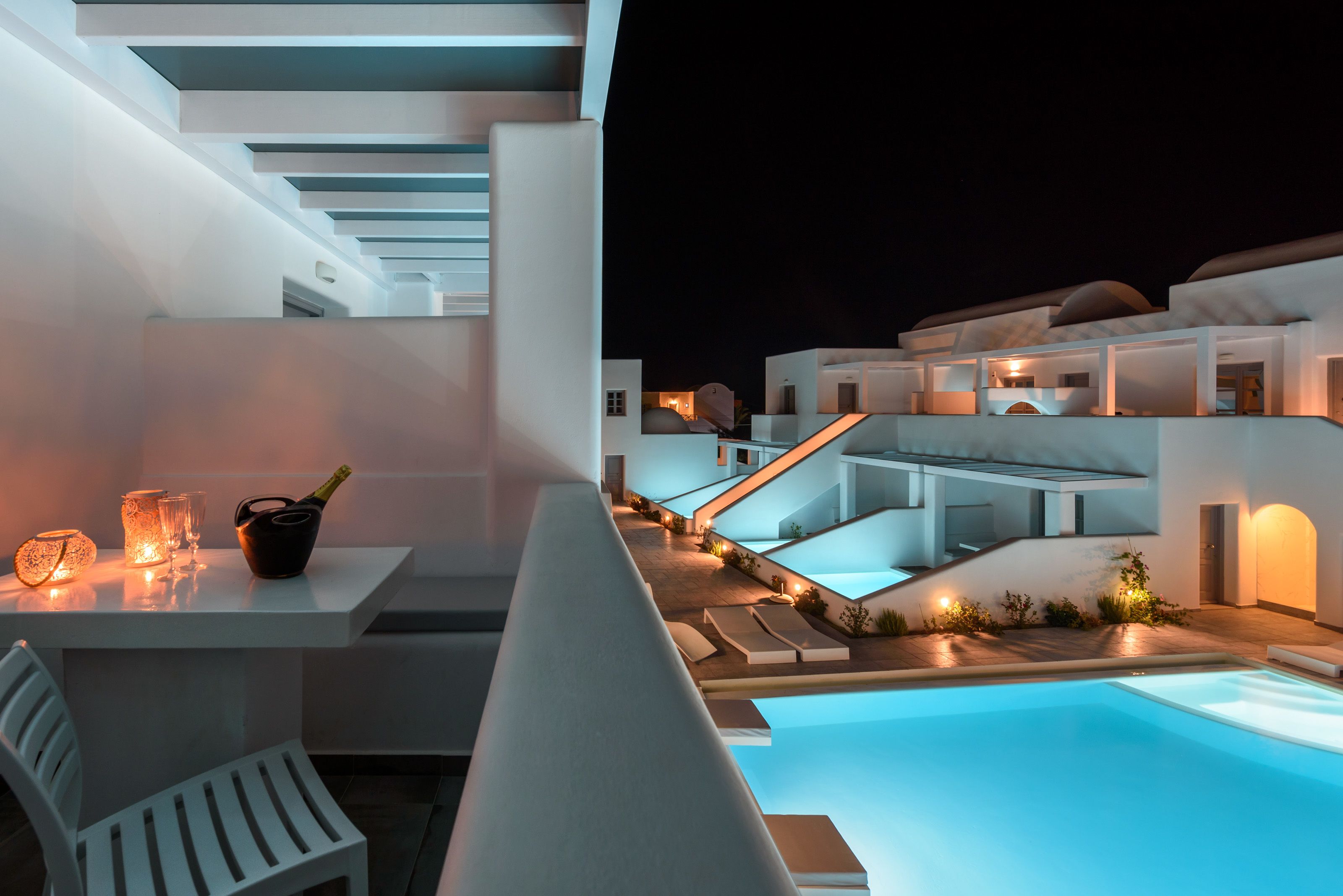 Um hotel moderno com piscina, área de estar ao ar livre e escadaria para andares superiores.