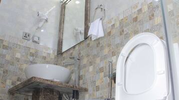 Casa de banho com lavatório branco, sanita e espelho.