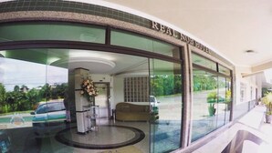 Um hotel Real NOB com área de recepção, entrada de vidro e vista para a rua.