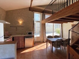 Uma cozinha com área de refeições, uma escada e vista para o exterior.