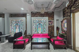 Quarto com lustre, lareira e uma grande janela de vitrais.