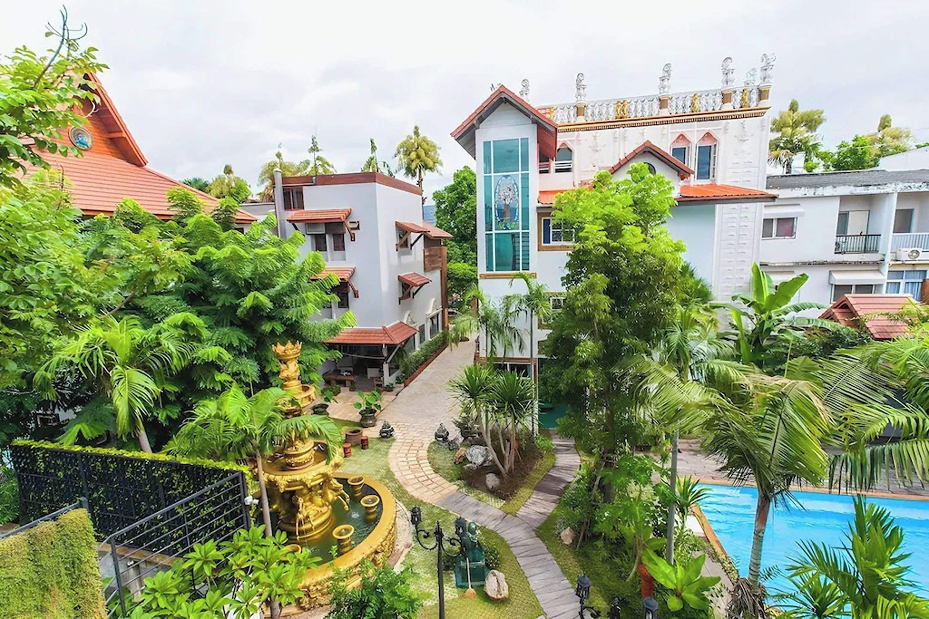 Resort com vários edifícios, piscina e vegetação exuberante.