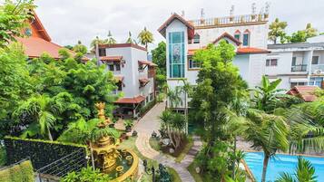 Resort com vários edifícios, piscina e vegetação exuberante.