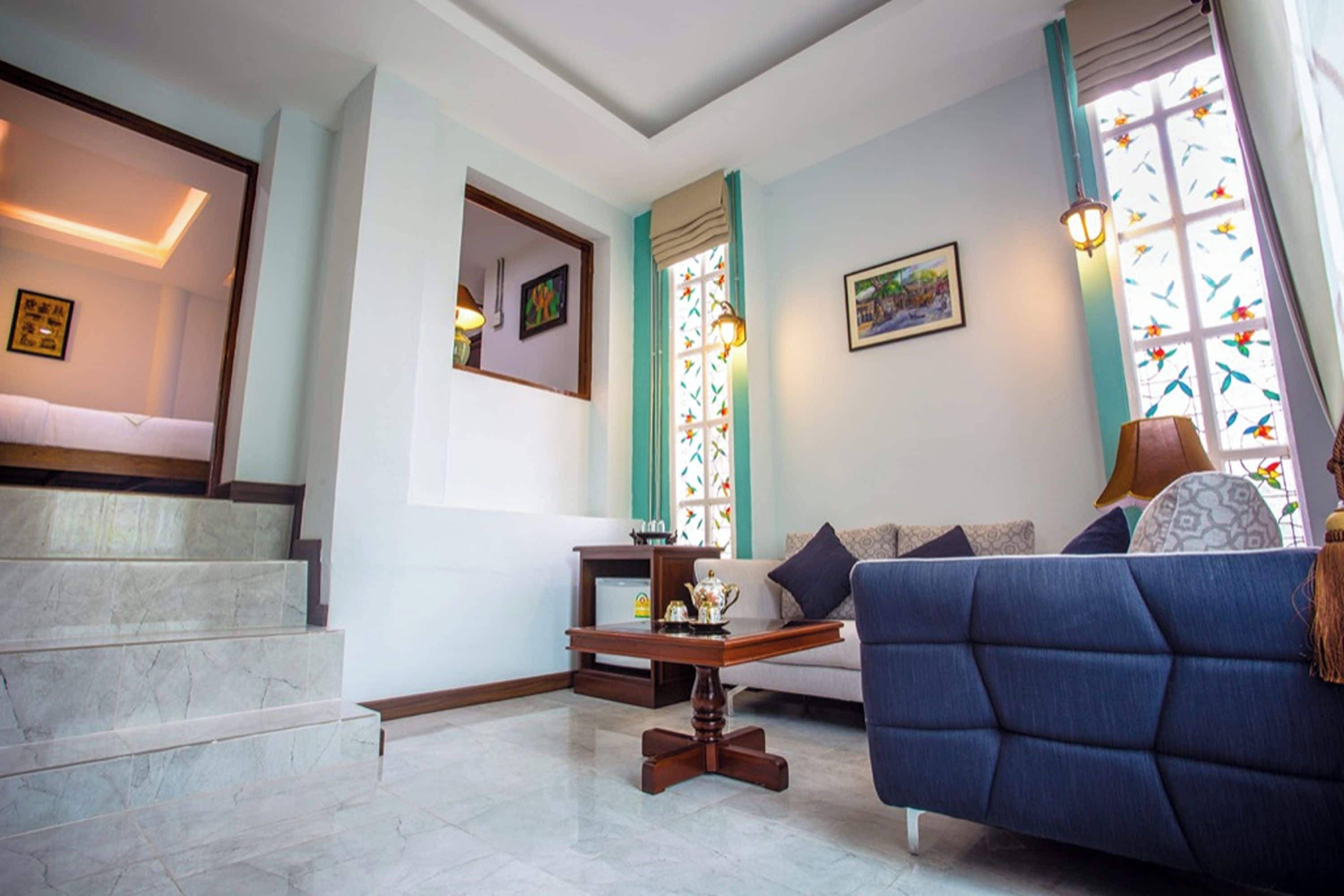 Uma sala de estar com sofá, mesa de centro e escada.