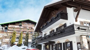 Um hotel de estilo arquitetônico alpino tradicional, com varanda de madeira e pilar de pedra.