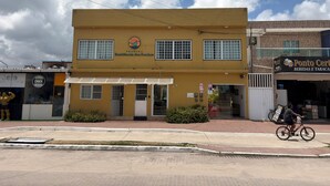 Um edifício de dois andares com fachada amarela, entrada visível e placa com a inscrição 'Ponto Certo Beidas e Tabaca'.