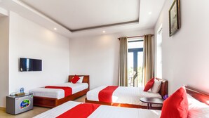 Quarto de hotel com duas camas, televisão, minibar e janela com cortinas.