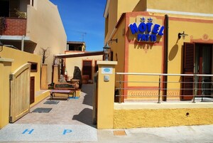 Um edifício amarelo com uma placa que diz 'HOTEL PATTI'.