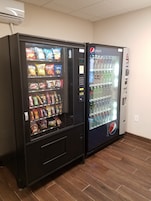 Máquina de vendas com lanches e um refrigerador de Pepsi.