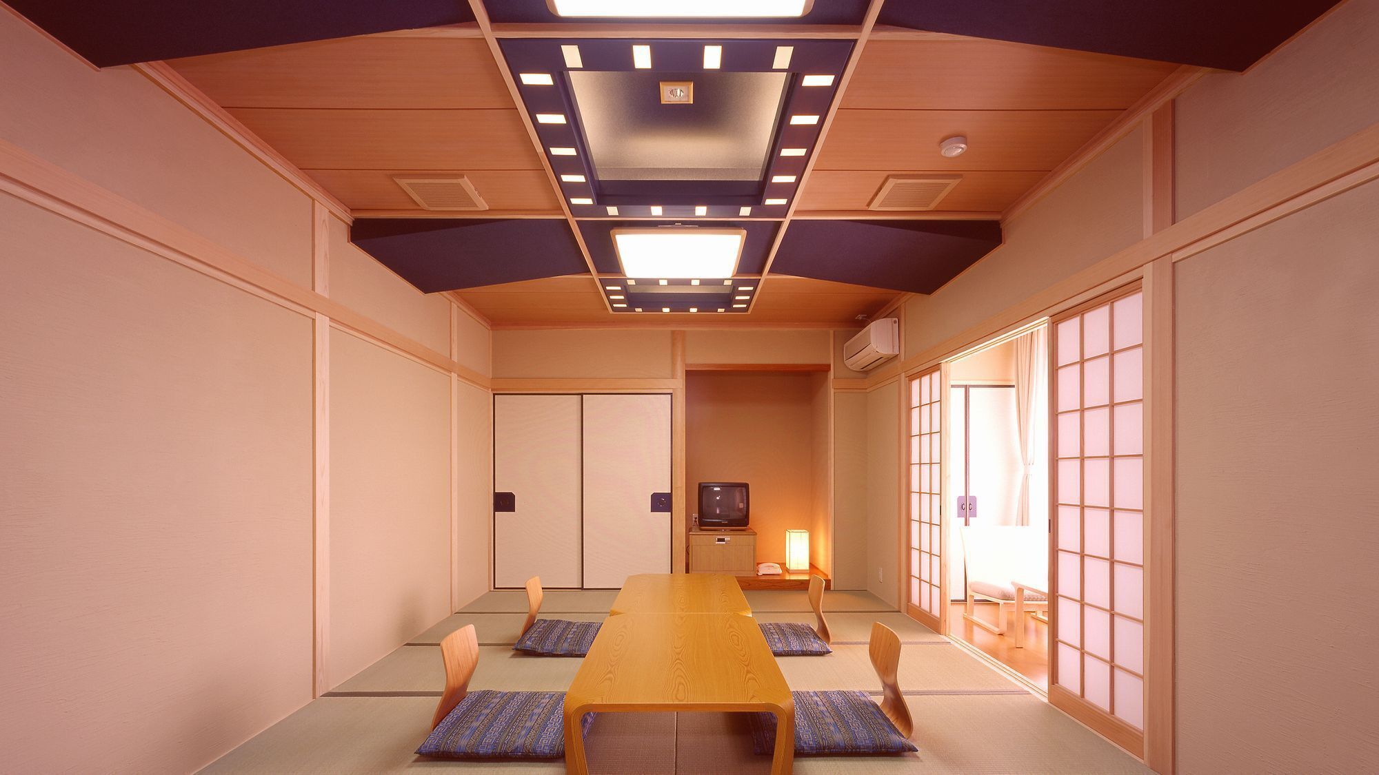 Um quarto japonês tradicional com tatames, uma mesa de madeira baixa e portas deslizantes.