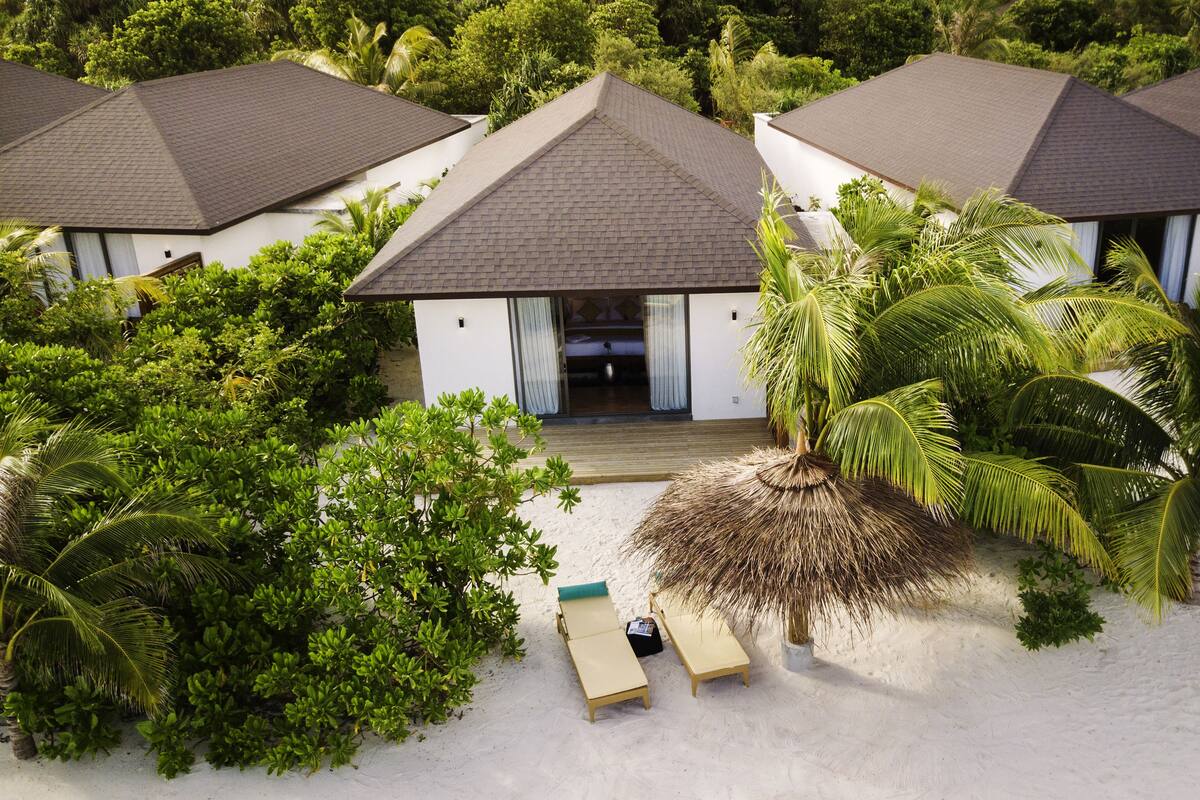 Resort com várias construções no estilo de bangalôs, cada uma com entrada privativa e telhado de palha.