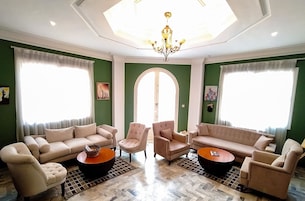 Uma sala de estar com um sofá, poltronas e uma mesa de centro.
