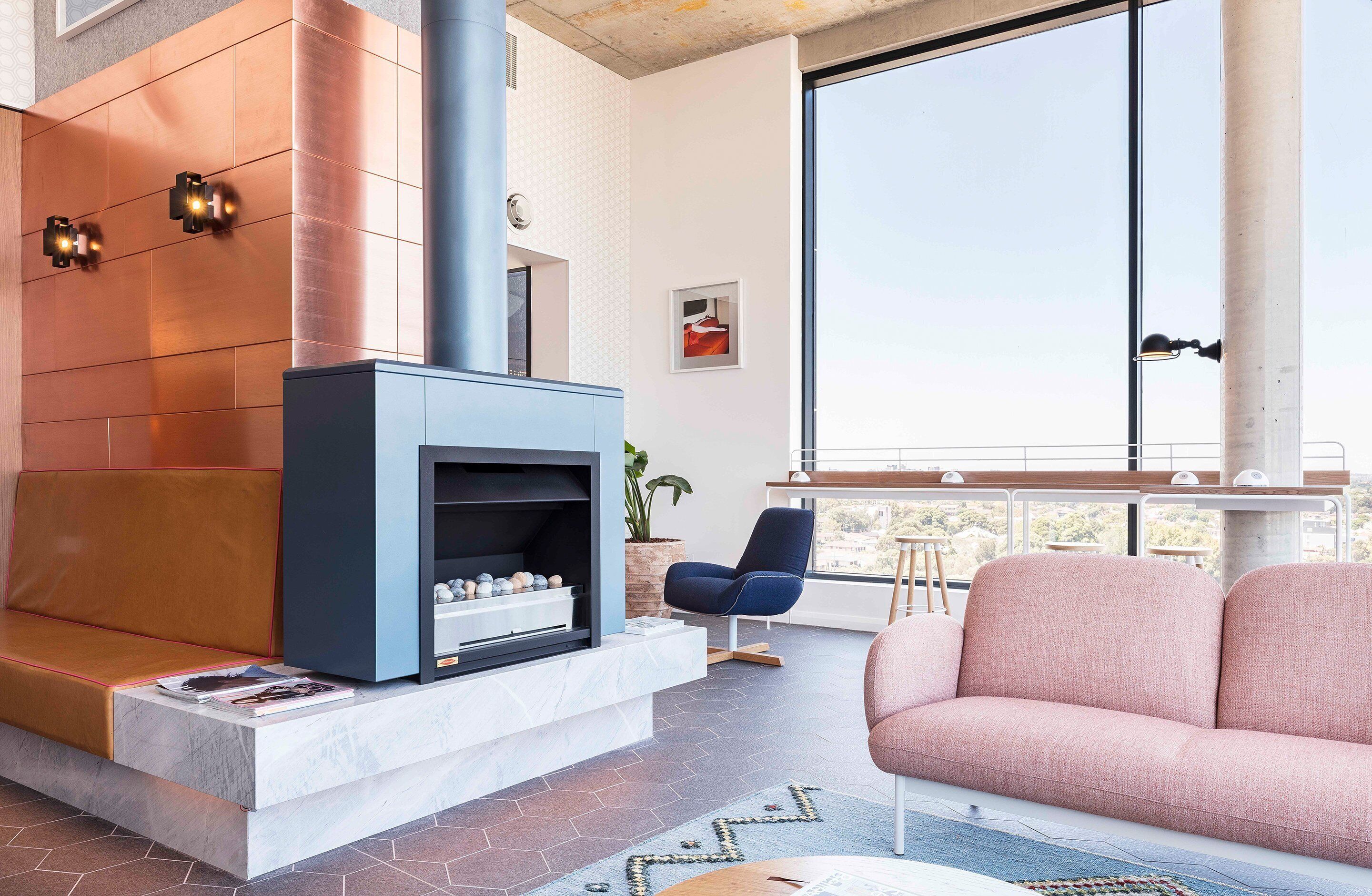 Uma sala de estar moderna com lareira, um sofá e uma poltrona.