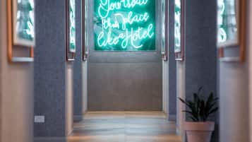 Um corredor com um letreiro de neon que diz: "Trate este lugar como um hotel".