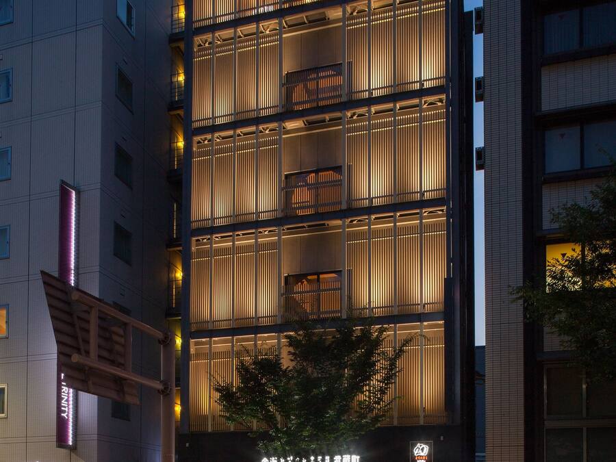 Um edifício de hotel moderno, com vários andares, janelas amplas e uma entrada imponente.