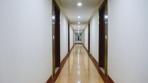 Um corredor comprido e estreito com piso brilhante e detalhes em madeira.