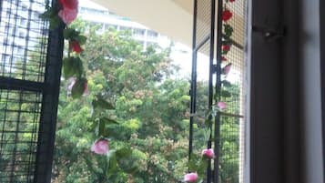 Varanda com grade de metal adornada com rosas vermelhas e cor-de-rosa.