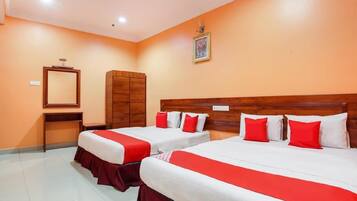 Quarto de hotel com duas camas, cabeceira de madeira, guarda-roupa, espelho e uma mesa pequena.
