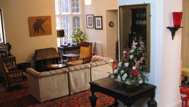Uma sala de estar aconchegante com sofá, mesa de centro de madeira e um espelho grande.