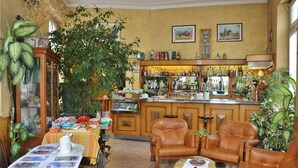 Um quarto aconchegante com poltronas de couro, um espaço de bar com garrafas e uma planta grande.