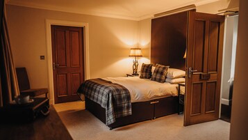 Quarto com cama, mesa de cabeceira, abajur e guarda-roupa.