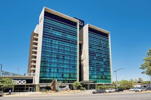 Um hotel moderno com fachada de vidro, vários andares e um letreiro chamativo com a inscrição 'HOTEL RO'.