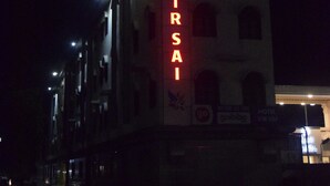 Um edifício com uma placa que diz "HOTEL VIRSAI" e o logotipo de uma flor vermelha e branca.