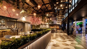 Espaço moderno em ambientes internos com área de bar, assentos e iluminação decorativa.