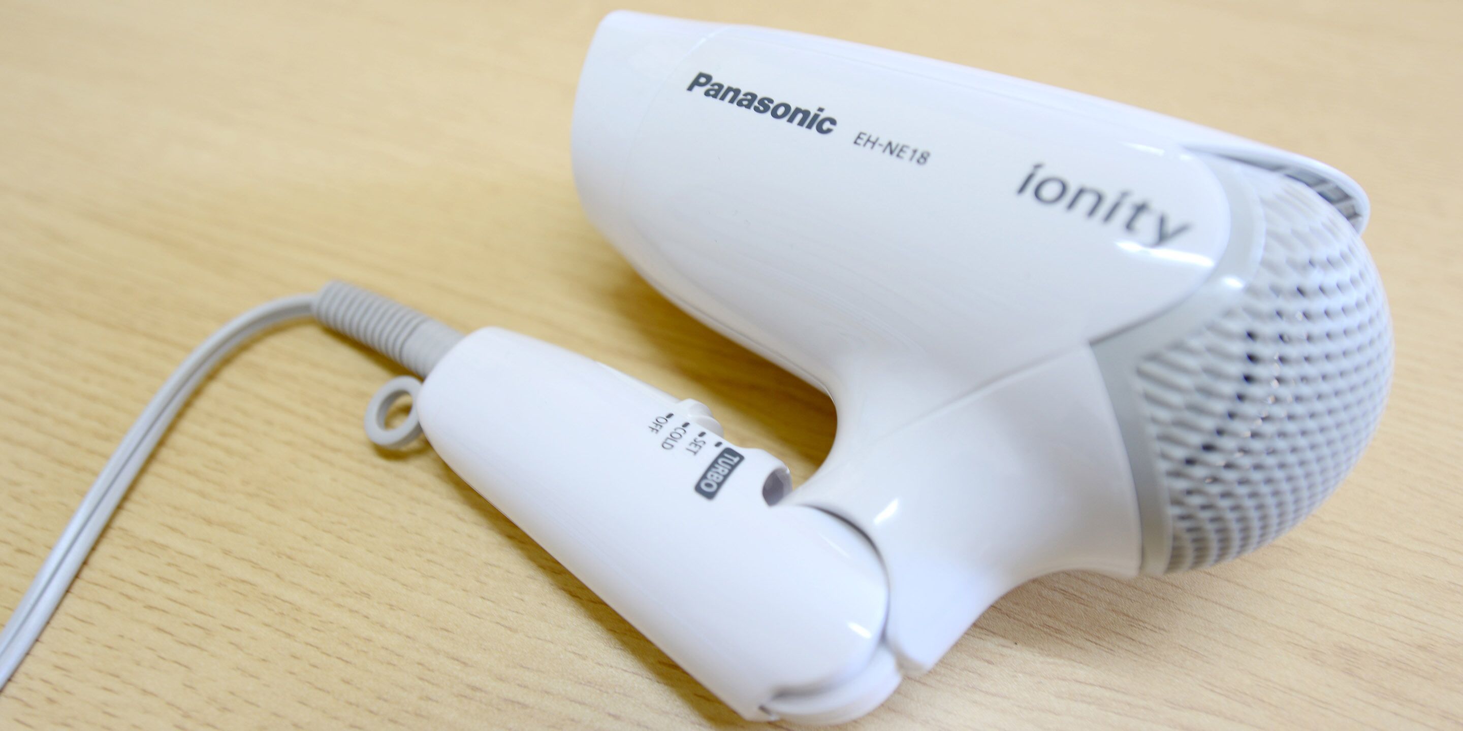 Um secador de cabelo Panasonic ionity sobre uma superfície de madeira.